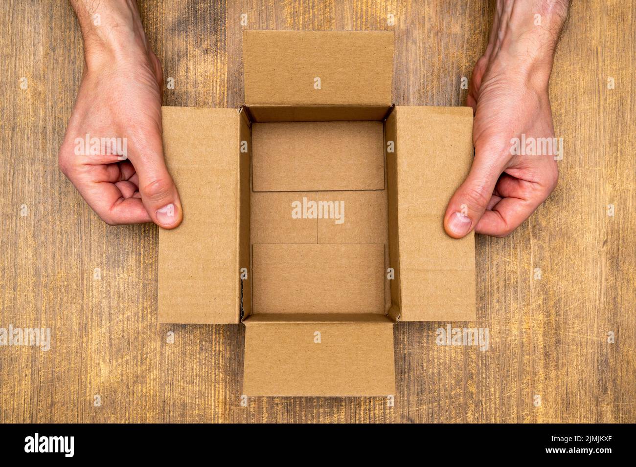 Hands opening empty brown cardboard box Stock Photo - Alamy