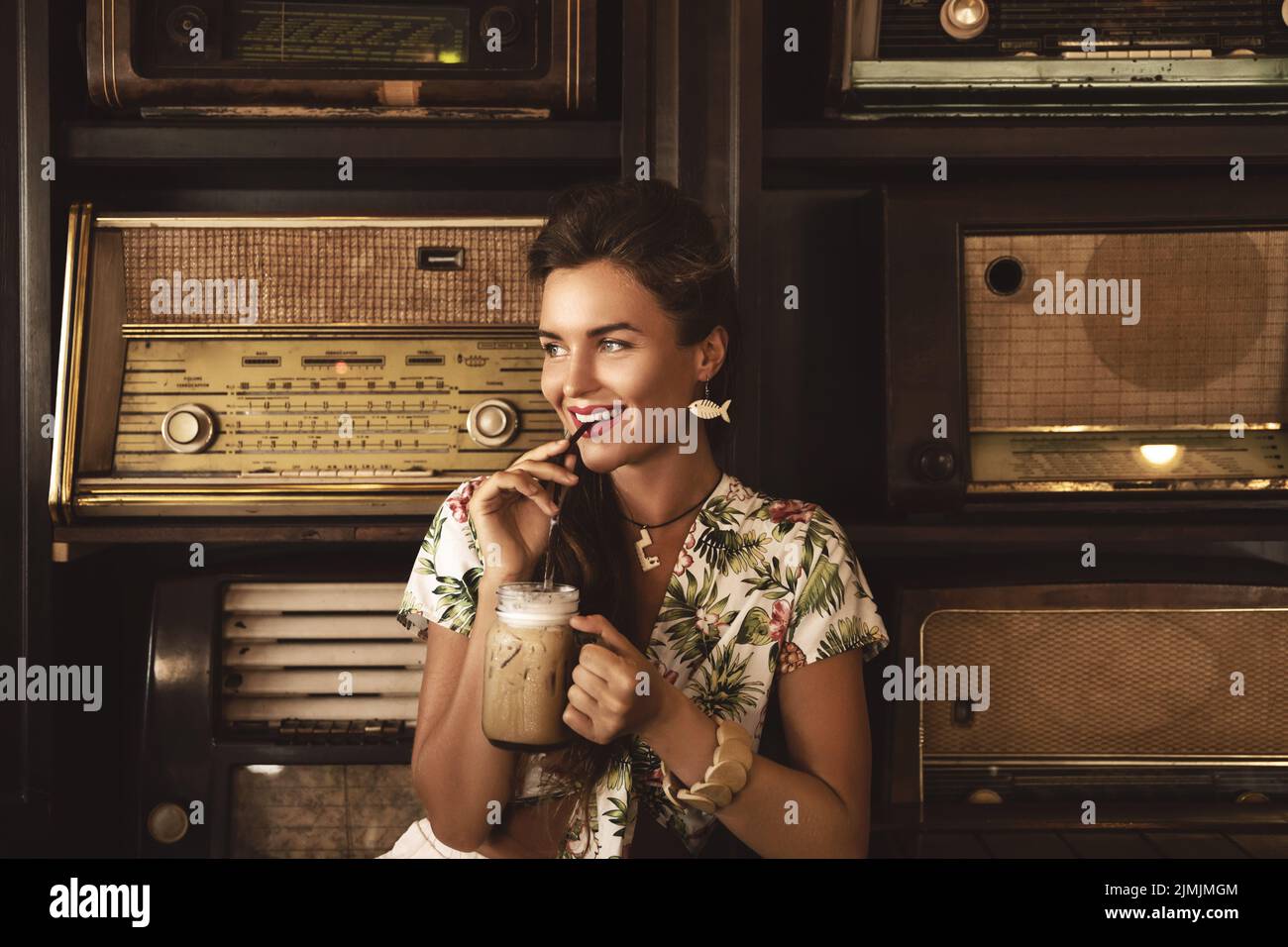 Young happy woman drinking iced coffee in stylish retro cafe Stock ...