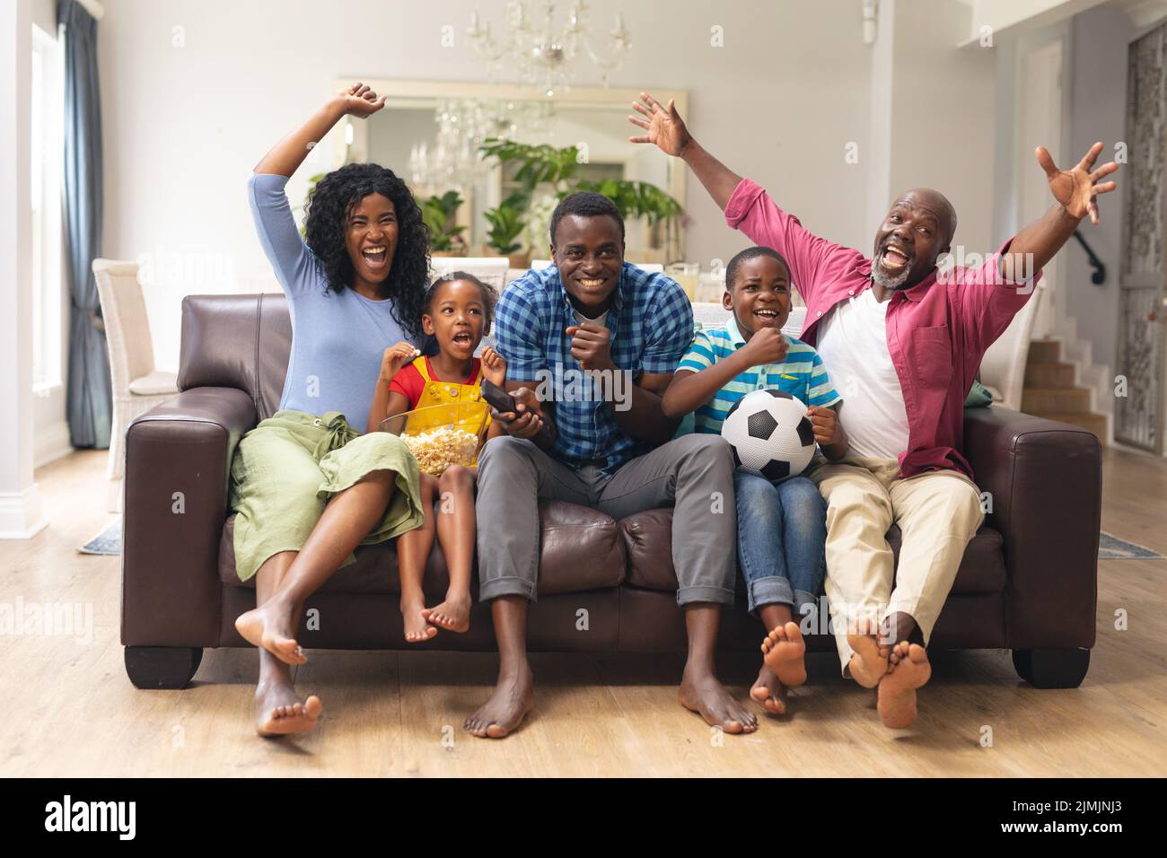 African american multi-generational family cheering while watching soccer match on tv Stock ...
