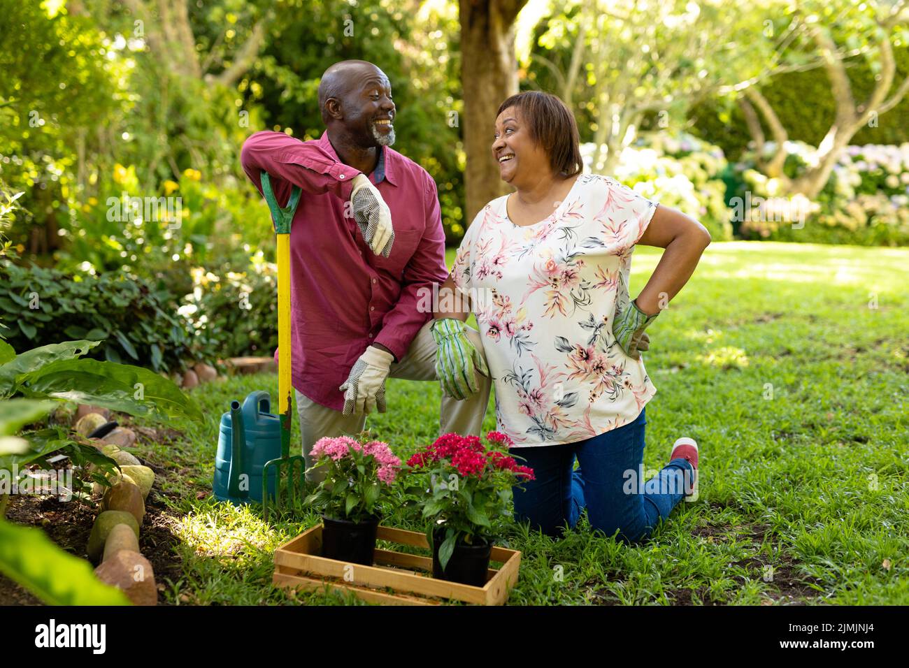 African american senior couple smiling while gardening together in ...