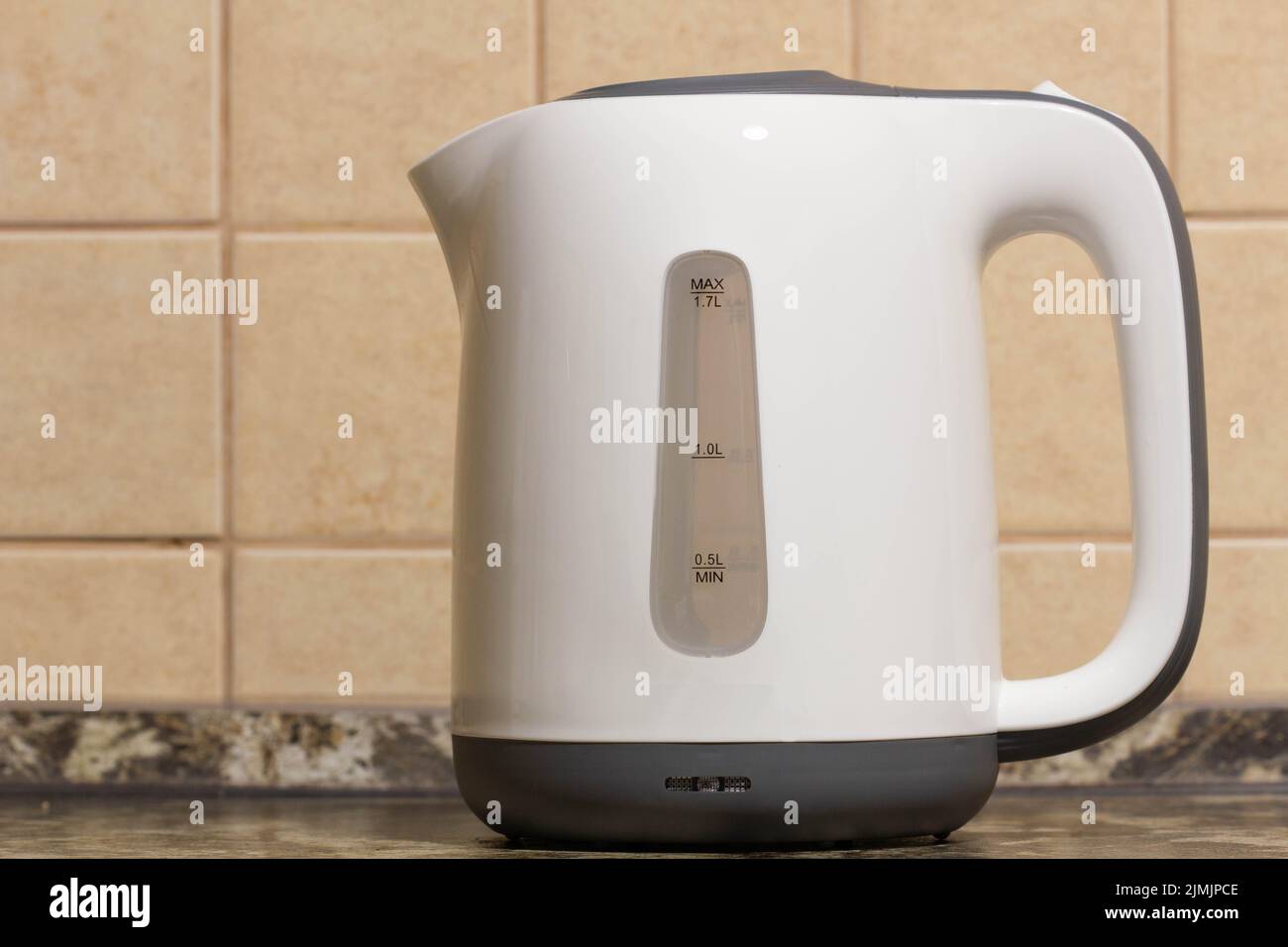 Electric kettle. White plastic electric kettle on the kitchen table ...