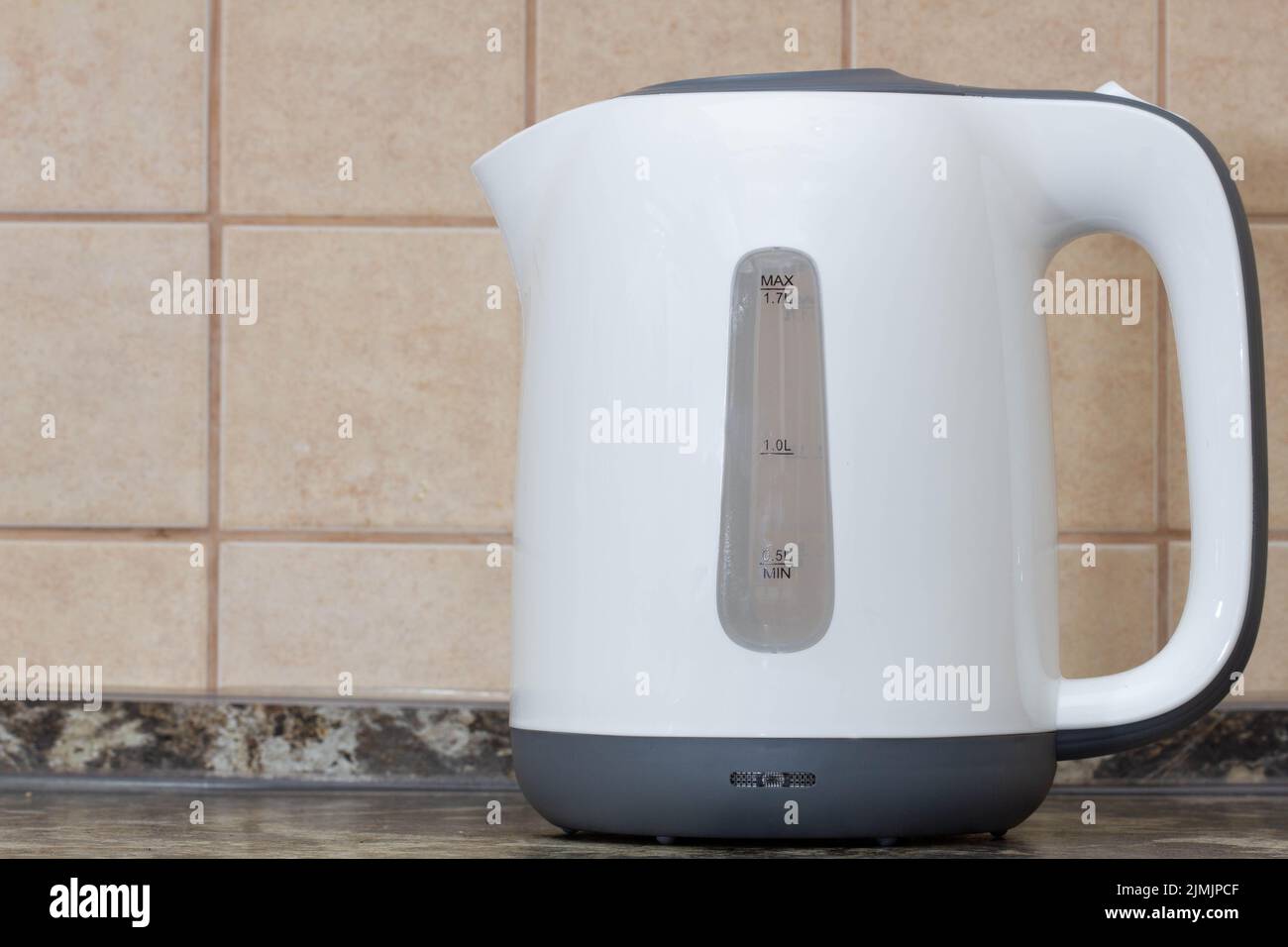 Electric kettle. White plastic electric kettle on the kitchen table ...