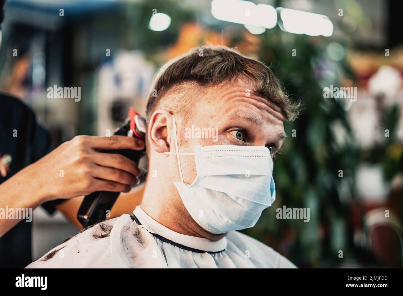 Lifestyle photo barbershop. Young man customer wears face mask ...