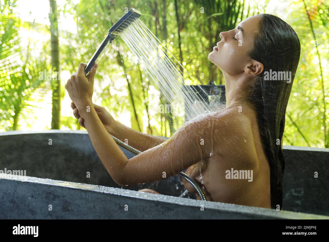 Woman washing under the shower in open air bathroom Stock Photo - Alamy