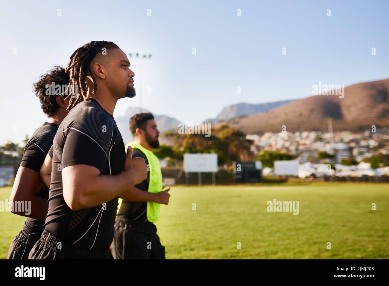Staying fit is part of the game. a diverse group of sportsmen warming ...