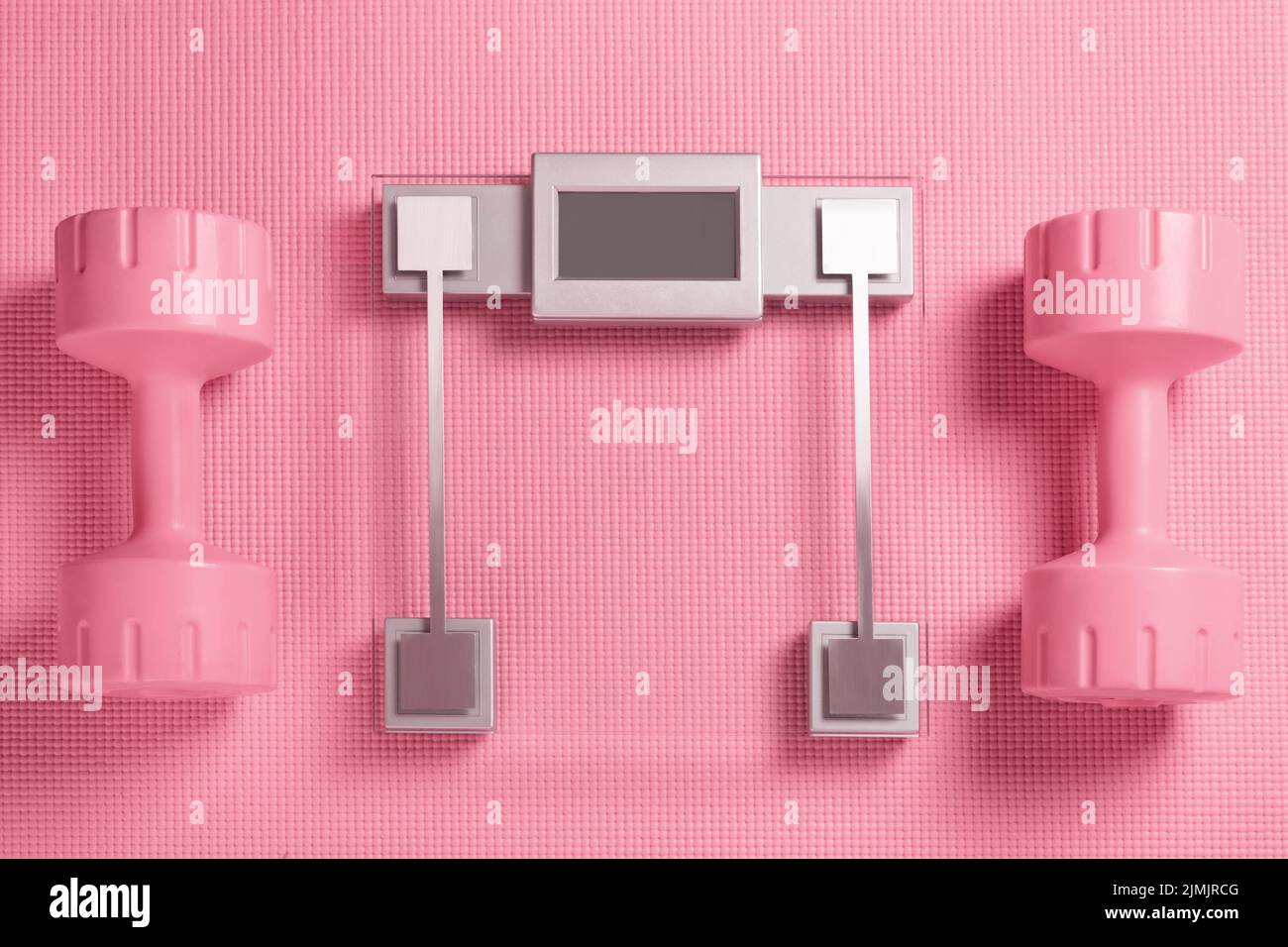 Dumbbells and bathroom scale on the fitness mat Stock Photo - Alamy