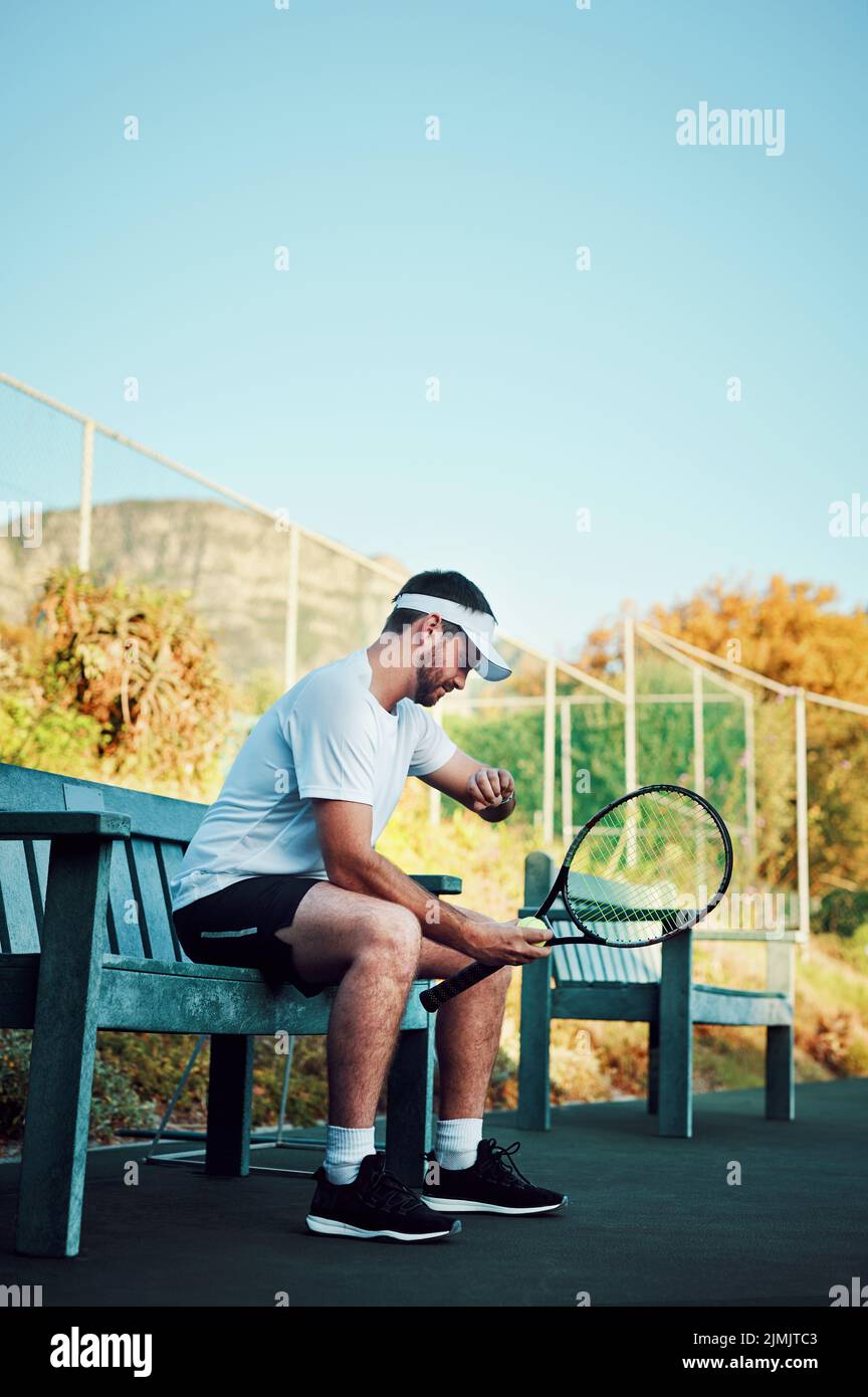 The match will begin soon. a sporty young man checking his watch while ...