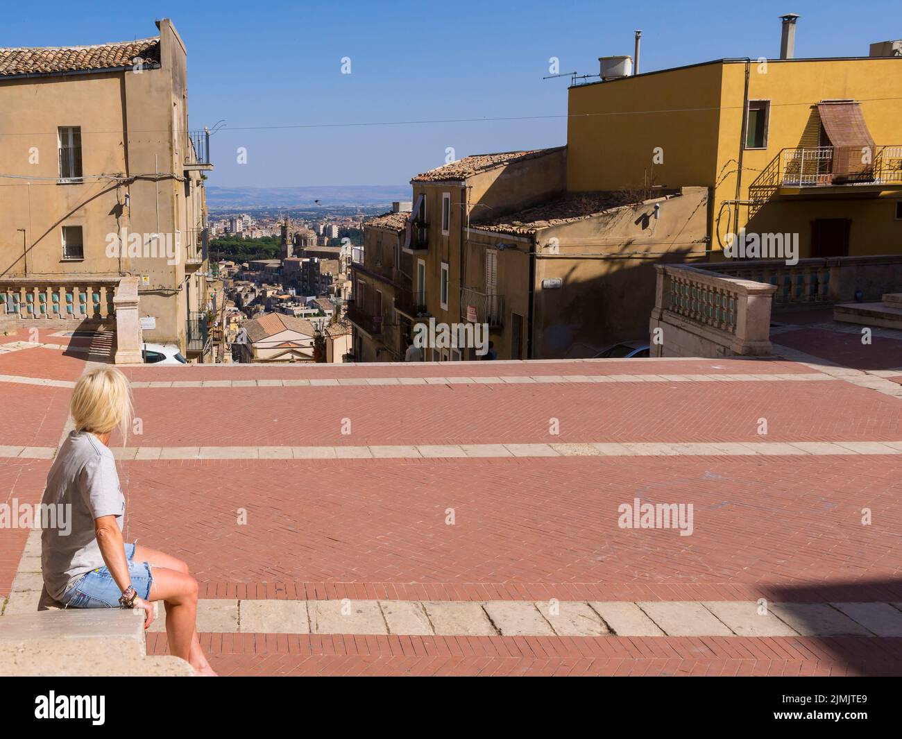 A woman looks at the stairs of Santa Maria del Monte and behind the ...