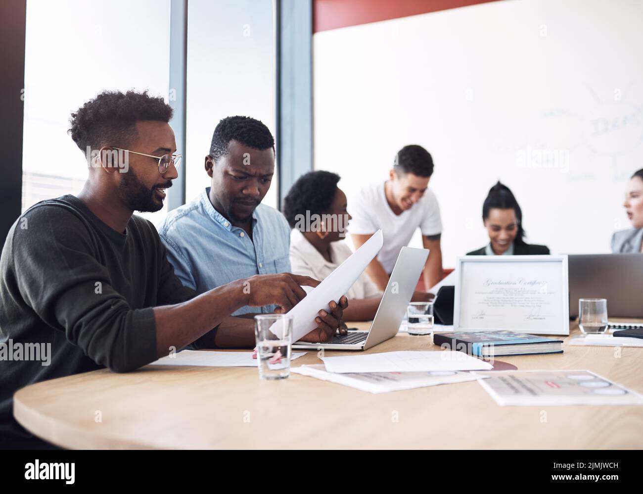 Helping a colleague understand the finer details. two businessmen going ...