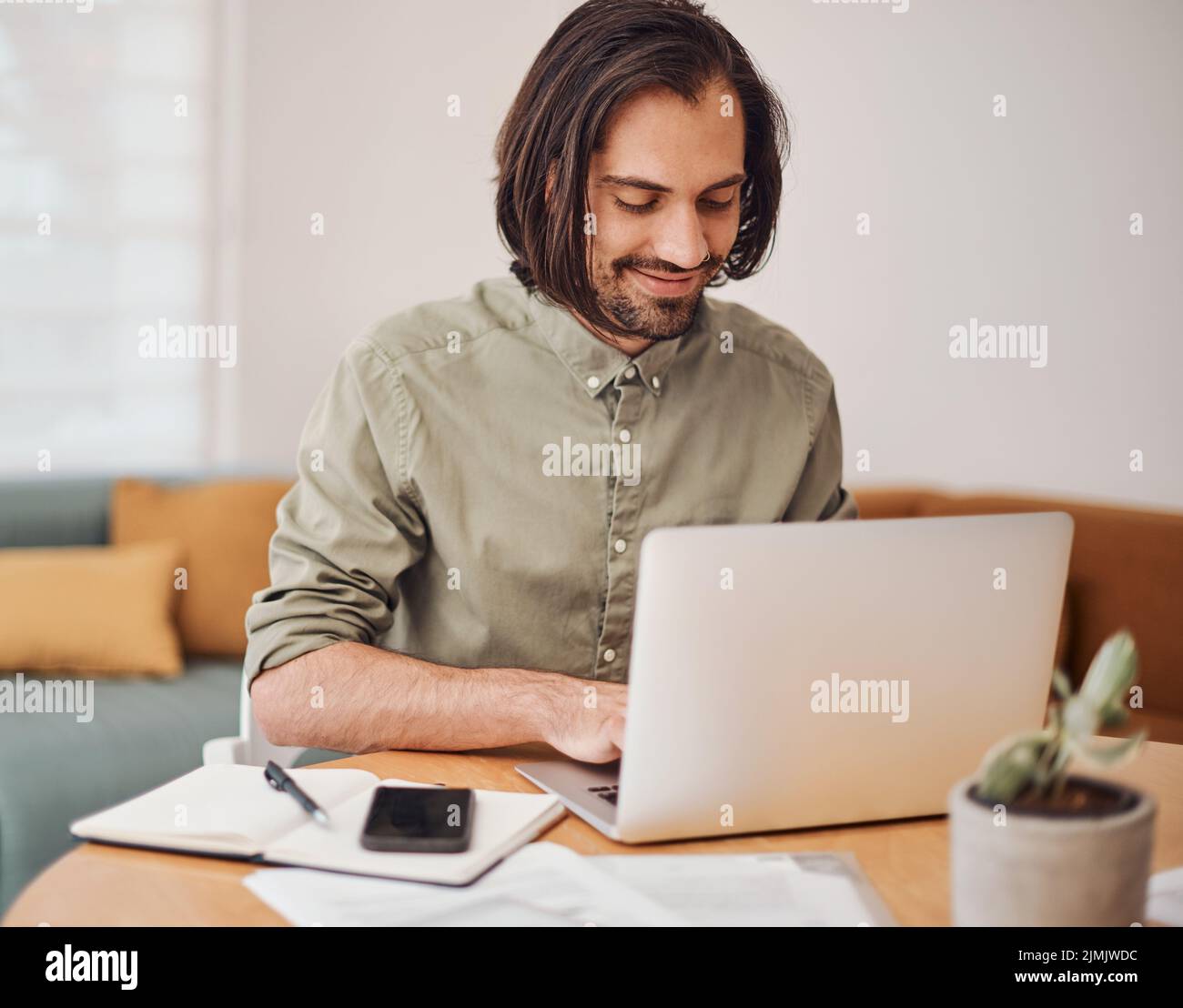 Making success all his. a young businessman using a laptop in an office ...