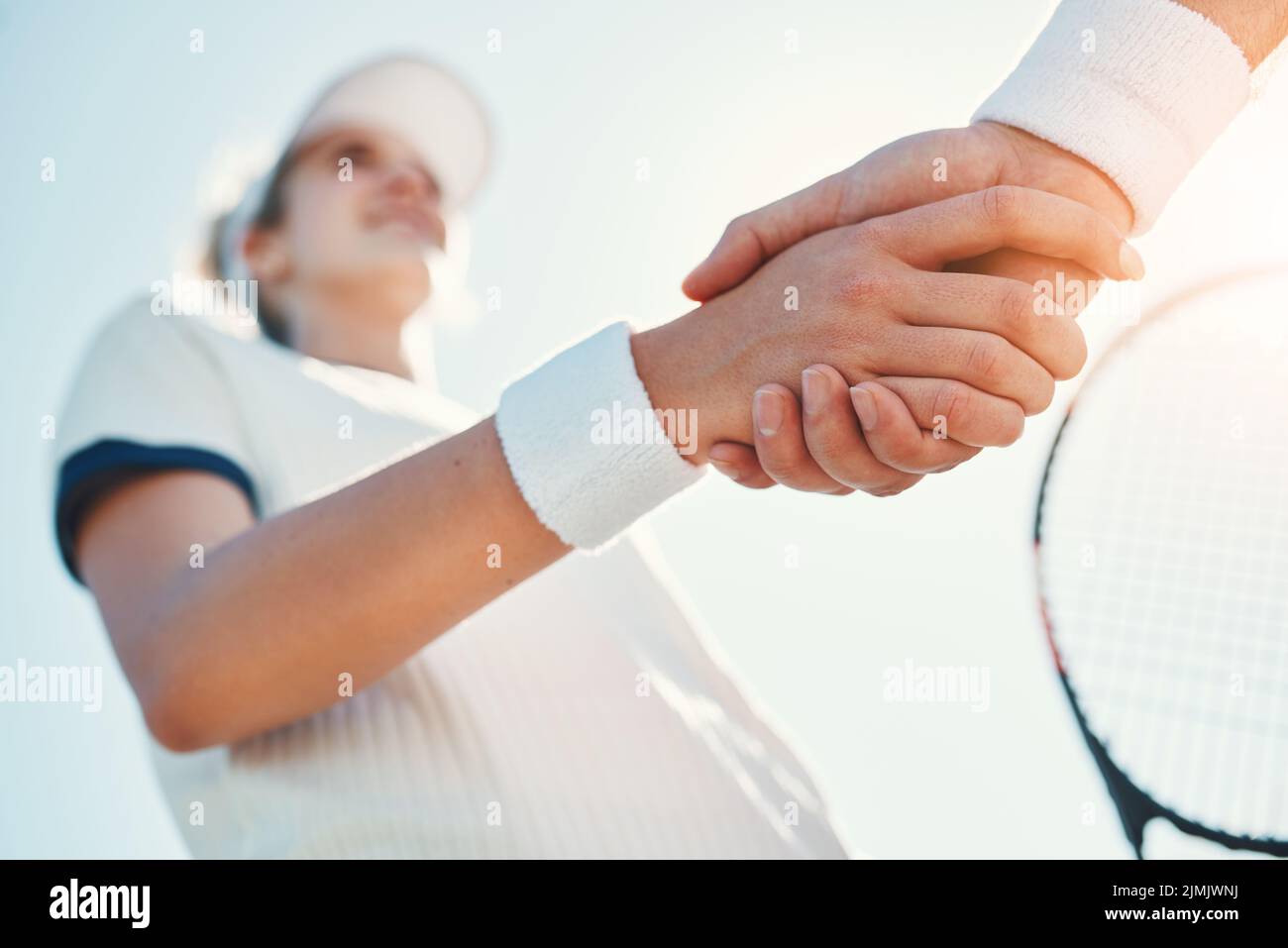 Good game. an attractive young female tennis player shaking hands with ...