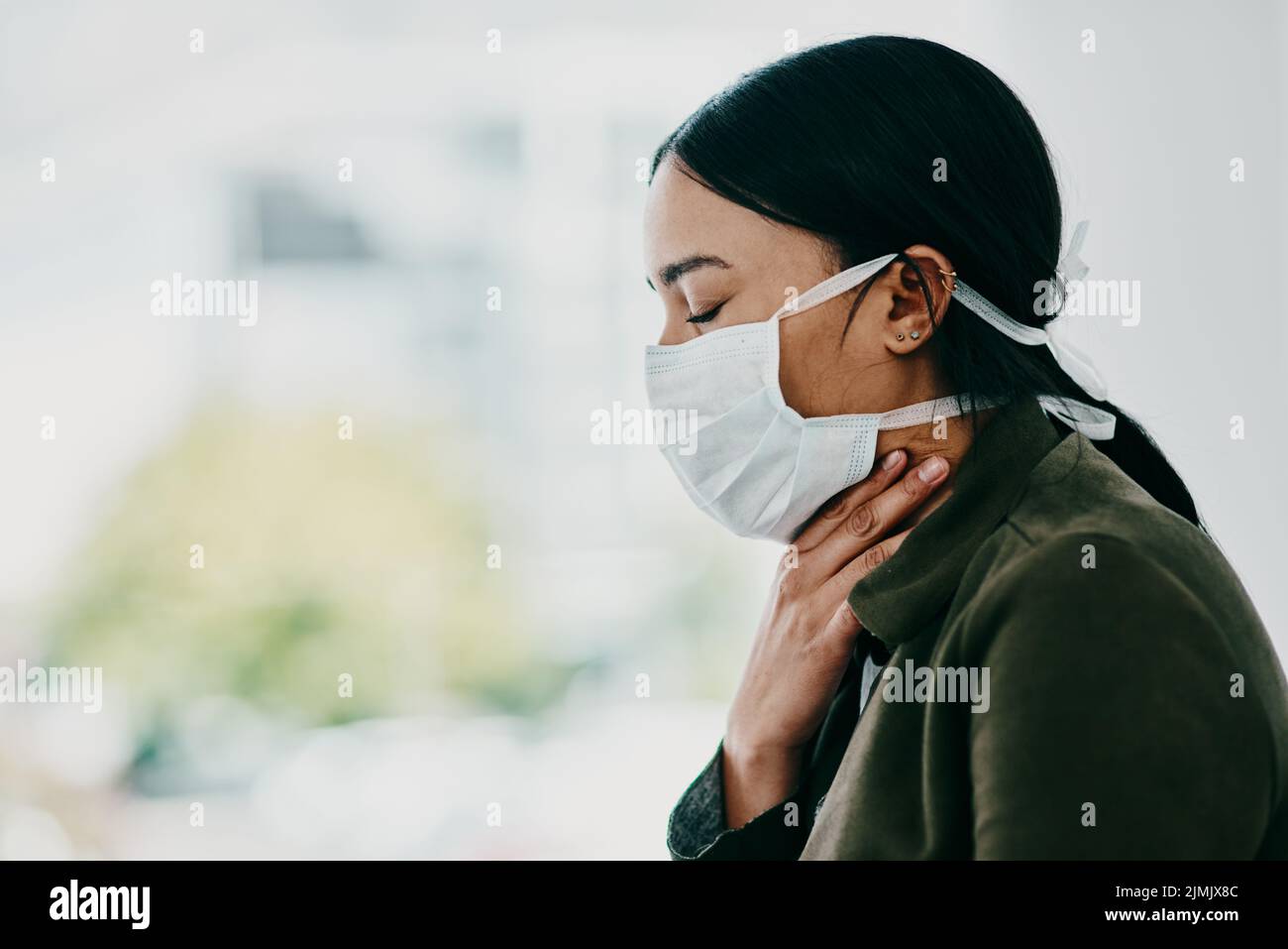 Take care, Covid-19 is here. a young woman wearing a mask and suffering ...