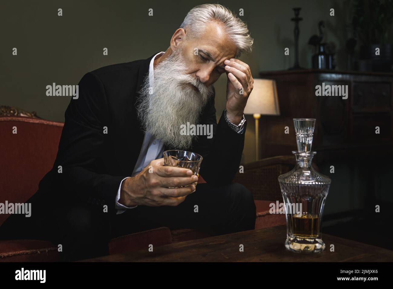 Handsome and bearded senior man drinking whiskey Stock Photo - Alamy