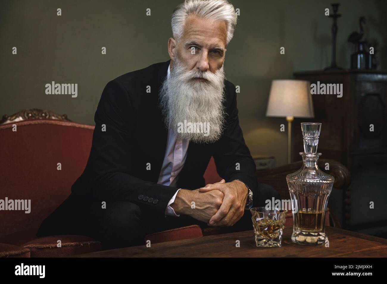 Handsome and bearded senior man drinking whiskey Stock Photo - Alamy