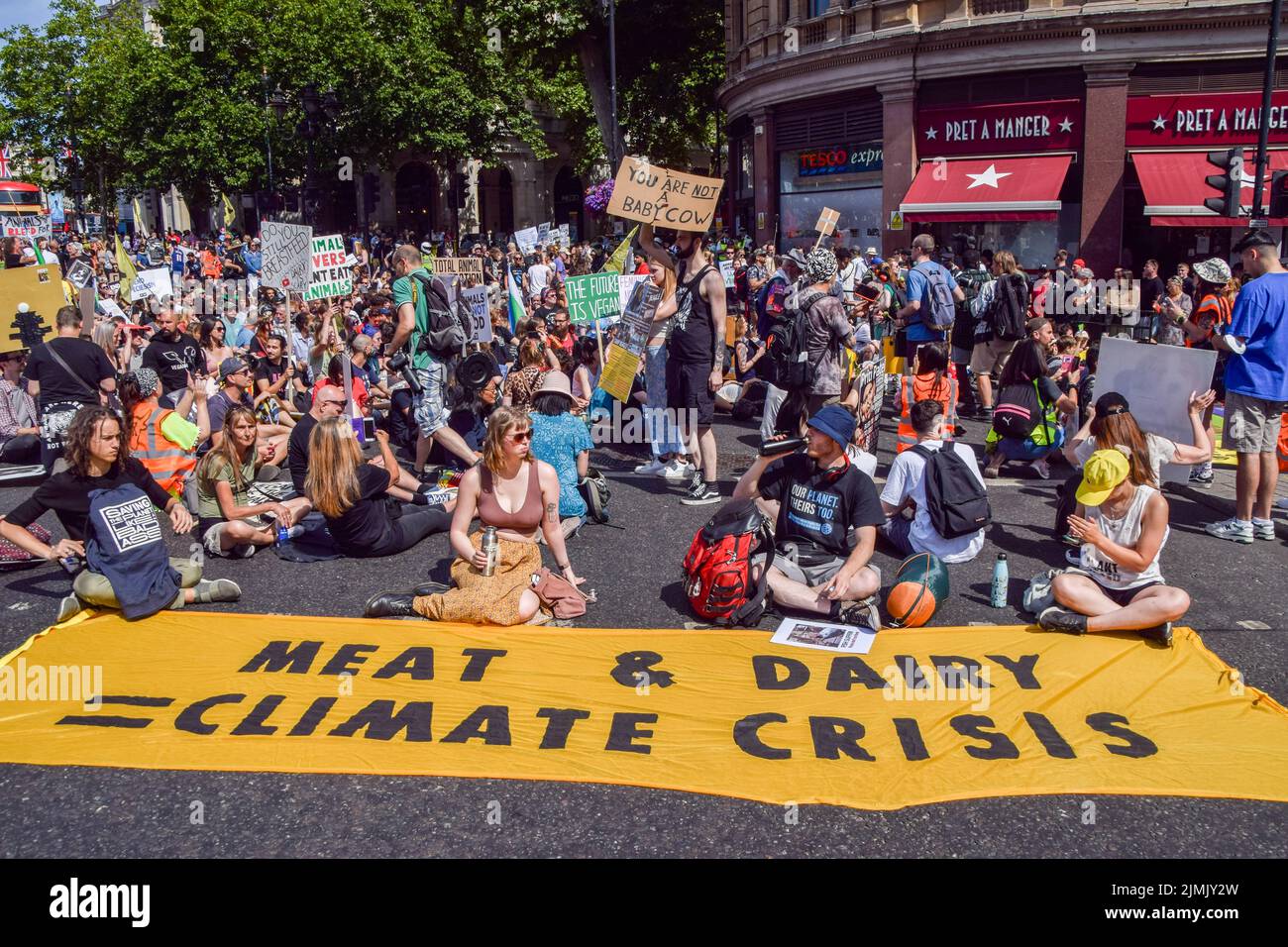 London, UK. 06th Aug, 2022. Protesters sit on the road next to a banner ...