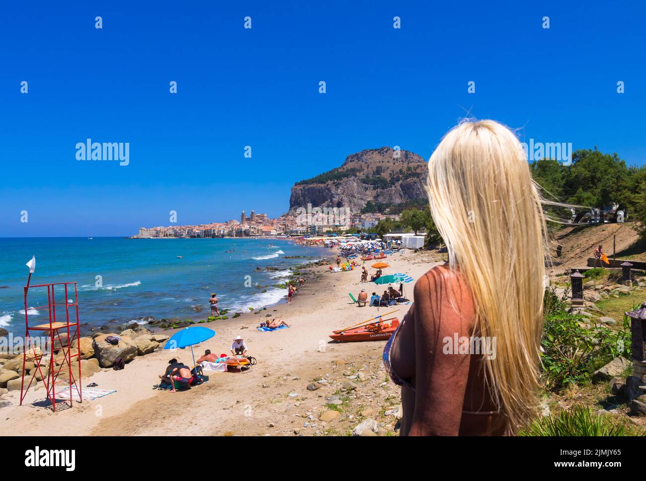 A woman looks at Cefalu with the cathedral Santissimo Salvatore and the ...