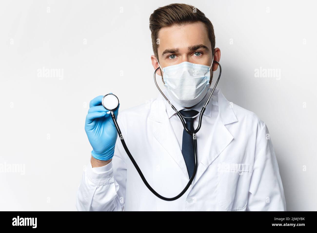 Doctor with the stethoscope wearing prevention mask and latex gloves ...