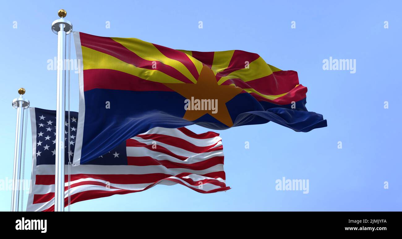 The flags of the Arizona state and United States waving in the wind ...