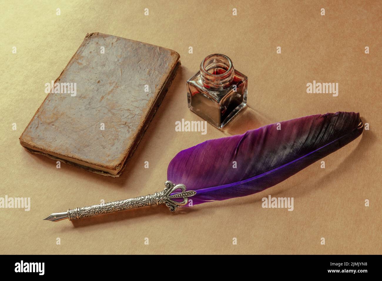A quill pen, a vintage ink well, and an old notebook, retro objects ...
