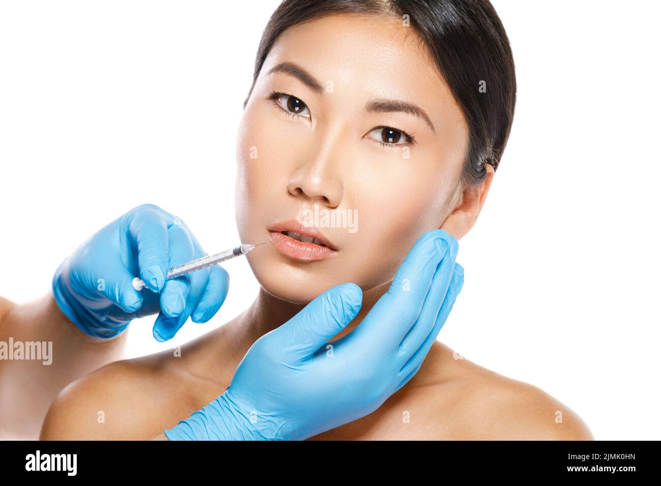 Asian woman during lips augmentation procedure on white background ...