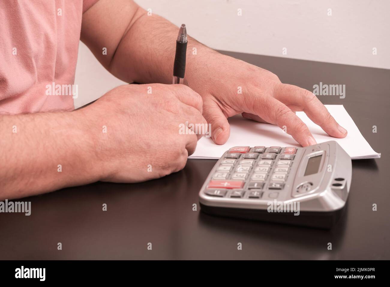 Unrecognizable Latino adult male doing math with calculator. Concept of ...