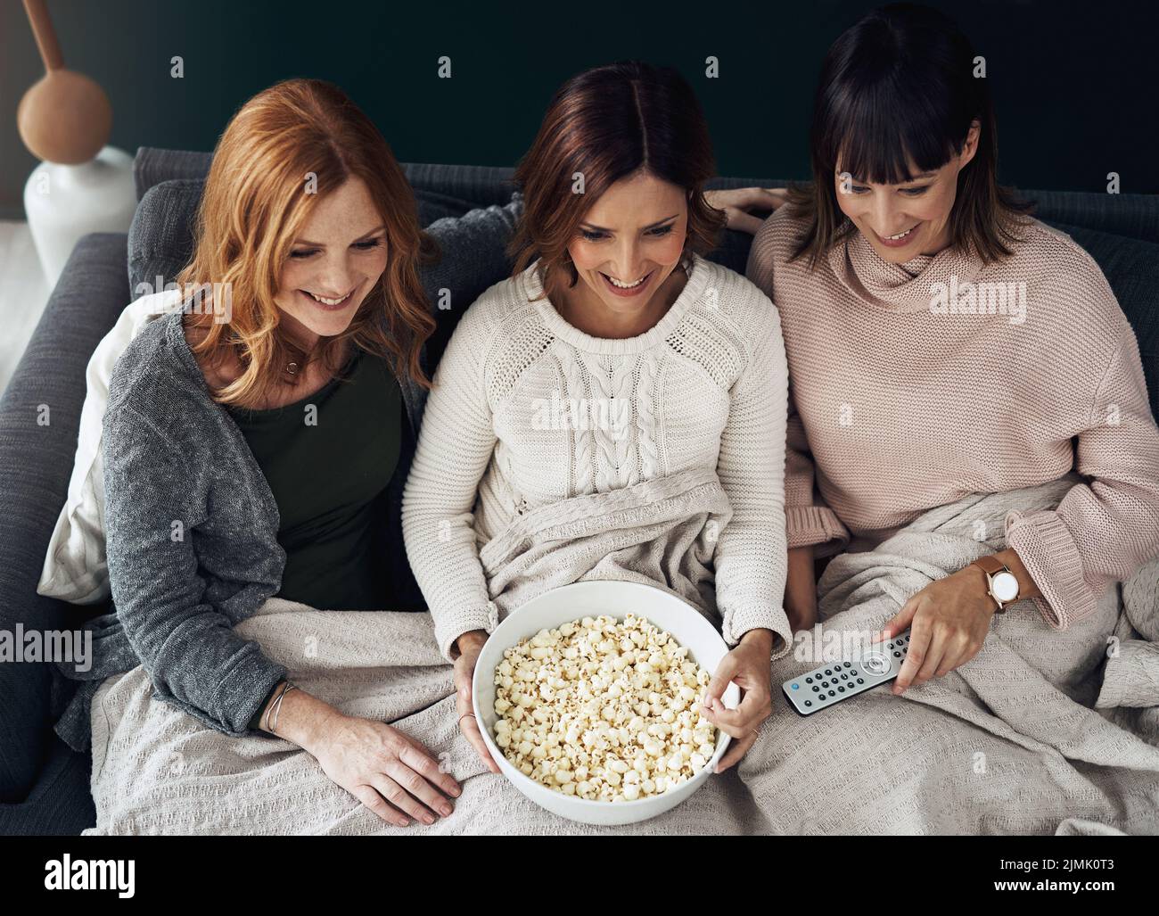 Anyone for popcorn. three middle aged women having a girls night at ...
