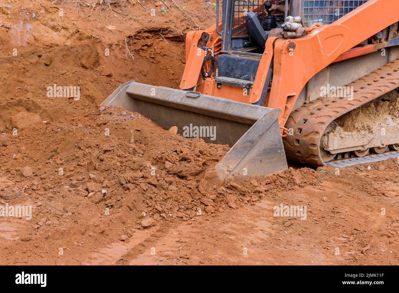 The land leveling near of new house requires use a small tractor with ...