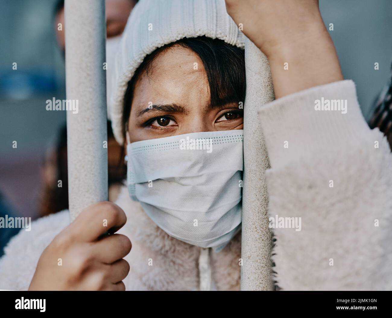 Please let me out. a young woman wearing a mask while stuck behind a ...