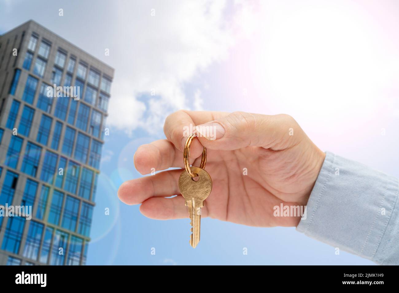 Apartment key in a man's hand. Brass house door lock key. High-rise ...