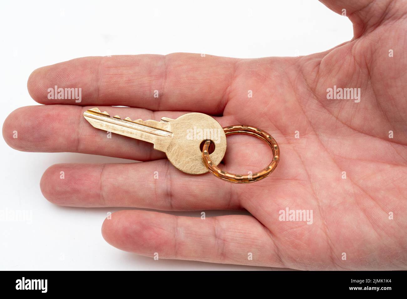Apartment key in a man's hand. Brass house door lock key Stock Photo ...
