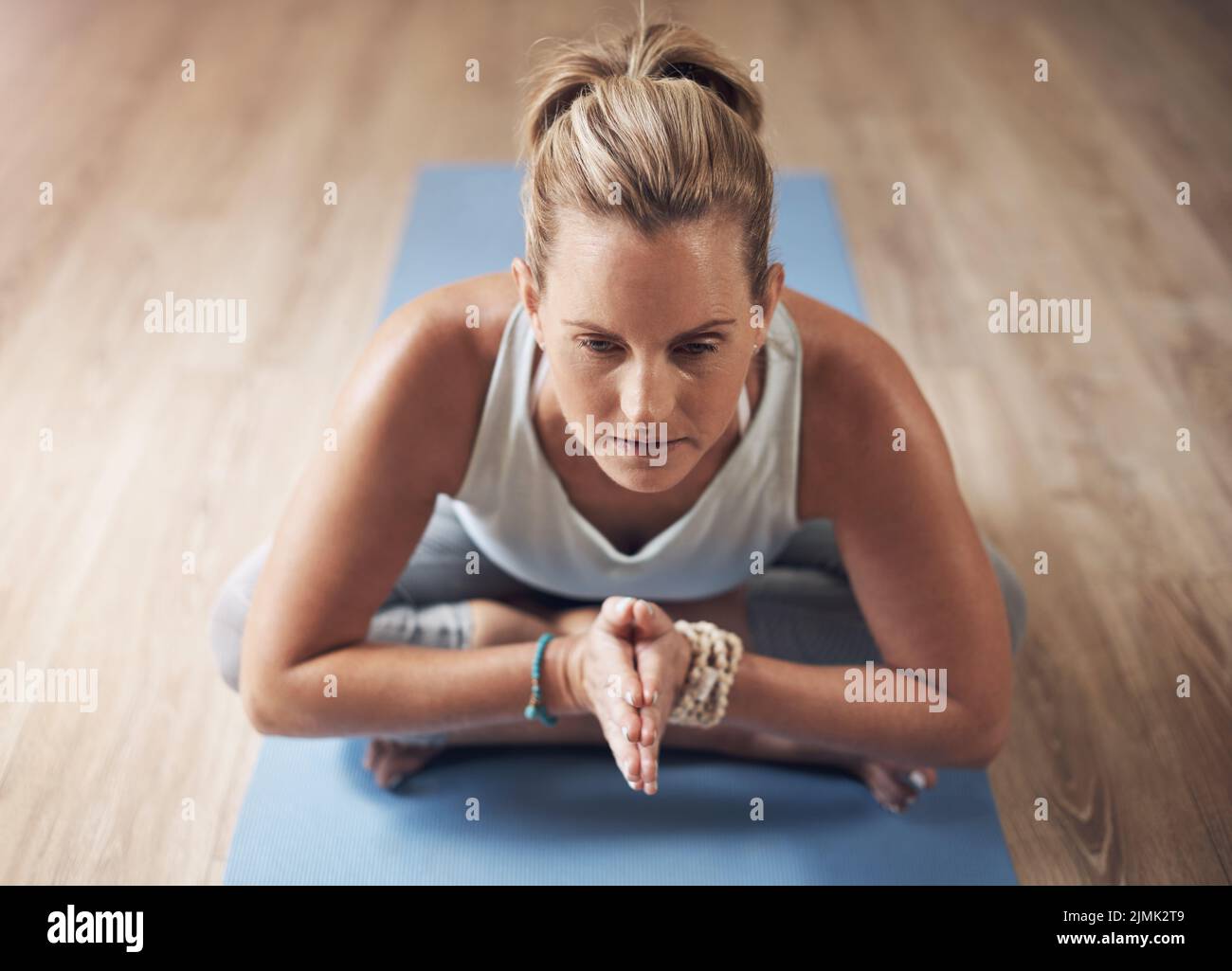 Focus on the breath. an attractive young woman sitting alone on a yoga ...