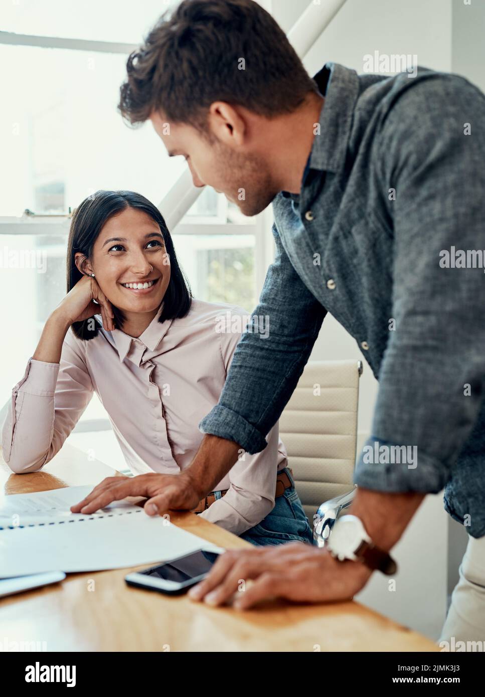 Checking in on how her day is going. two young businesspeople sitting ...