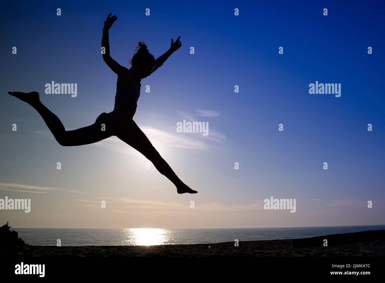 Dance jump performed outdoors in backlight Stock Photo - Alamy