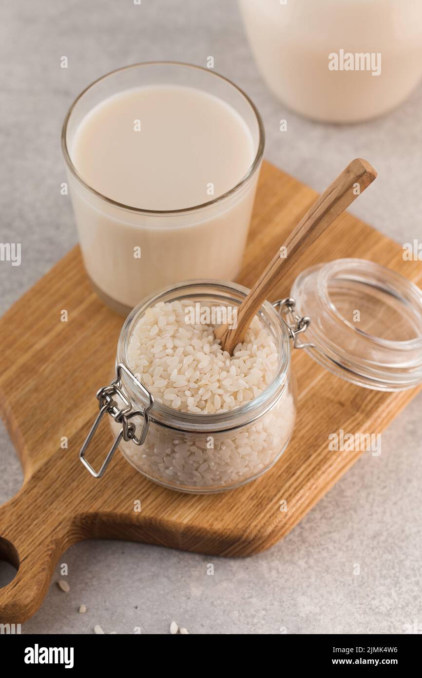 A jar of raw rice and rice milk in a glass on a plank. Healthy food ...