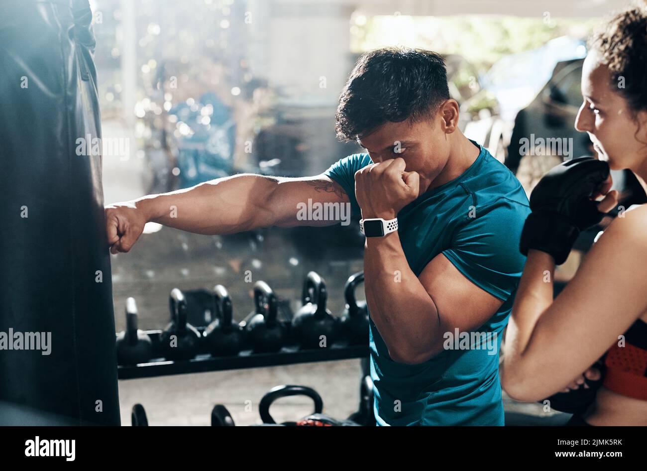 This is how its done. a handsome young male fitness instructor coaching ...