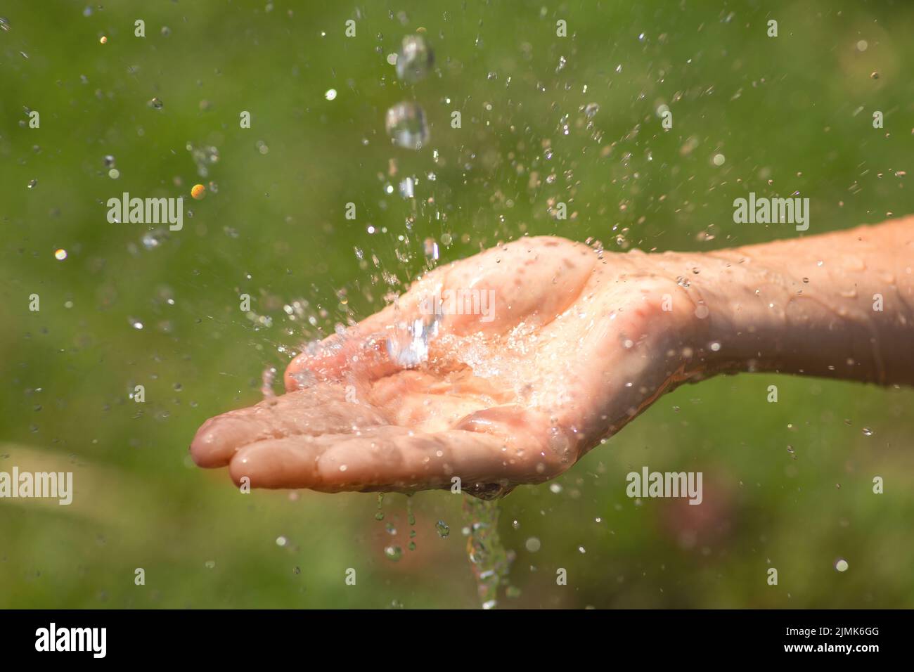 Wet female hands and clear water splashes Stock Photo - Alamy