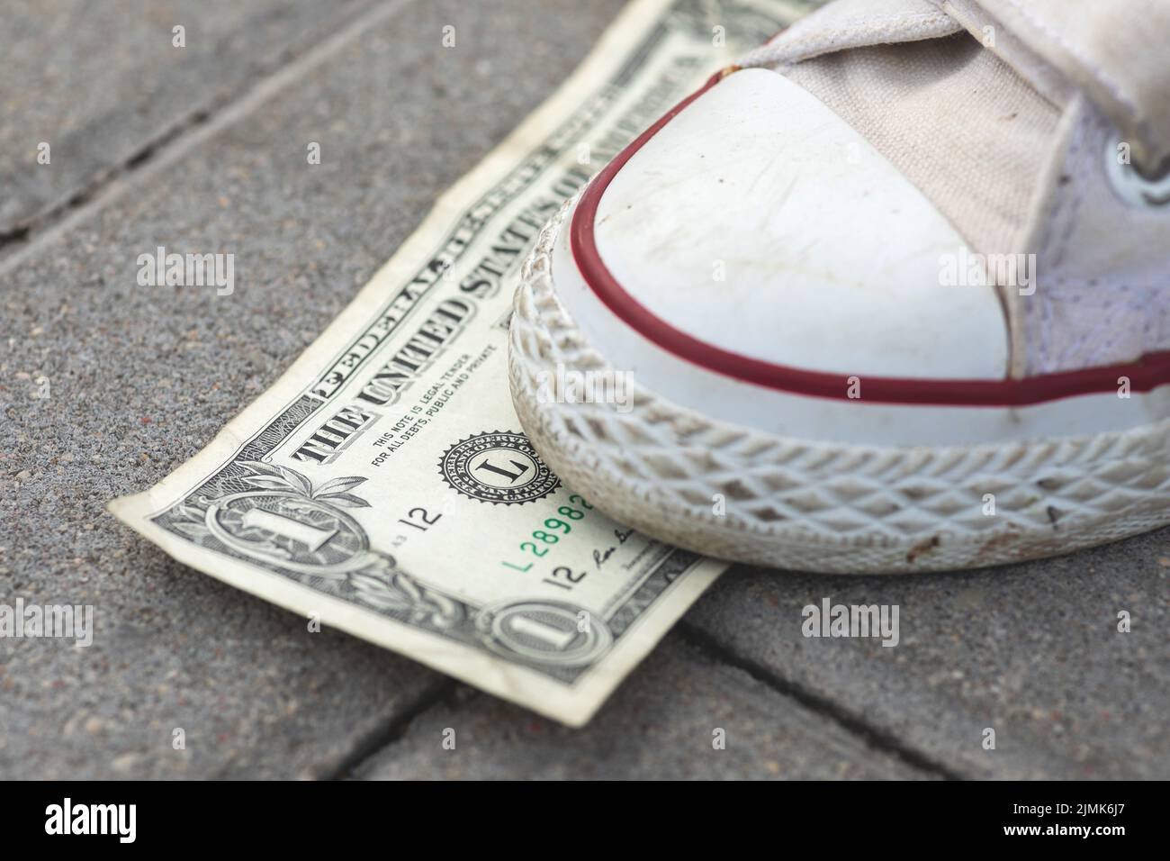 Female foot and one dollar banknote on the ground Stock Photo - Alamy