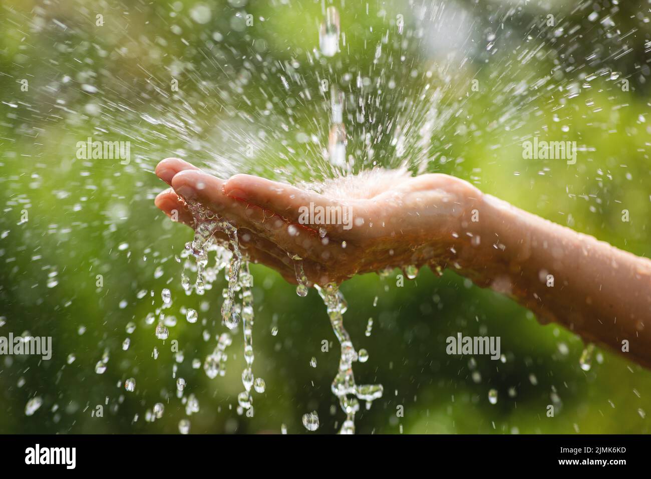 Wet female hands and clear water splashes Stock Photo - Alamy