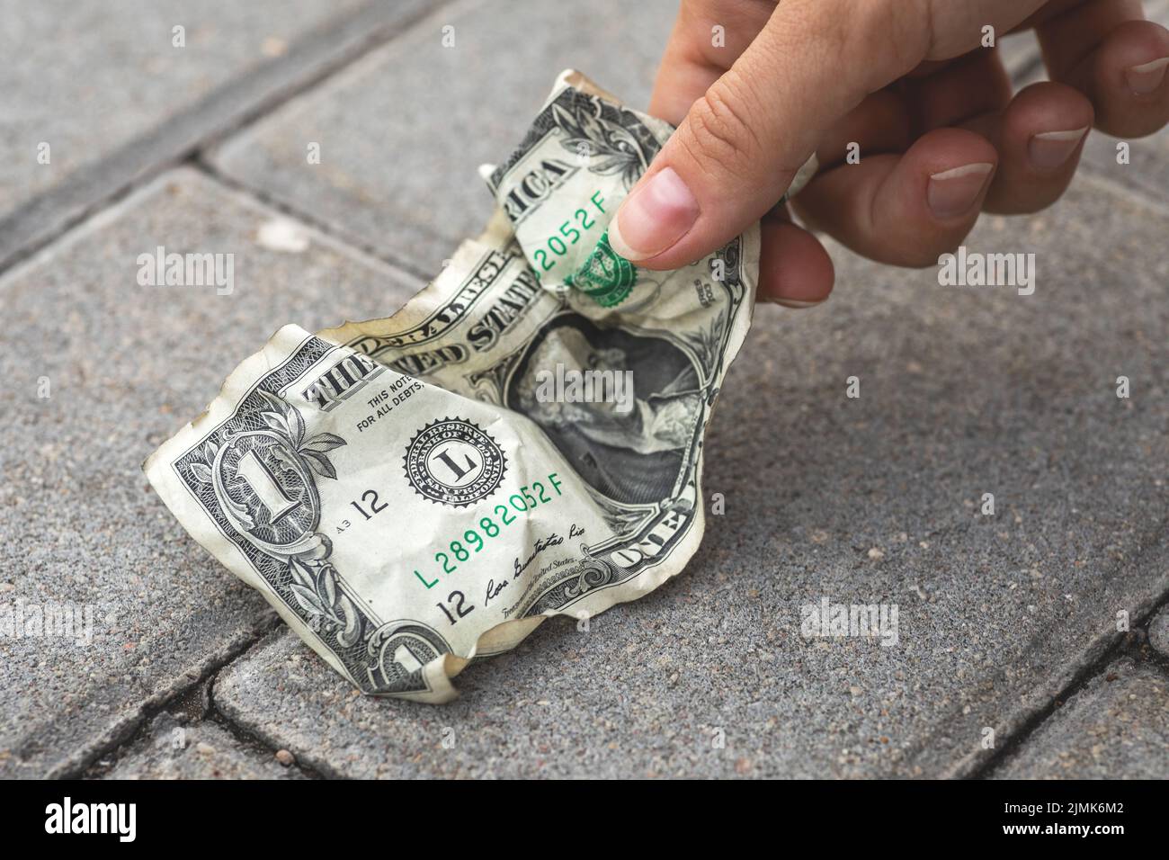Poor woman picking old and crumpled one dollar bill Stock Photo - Alamy