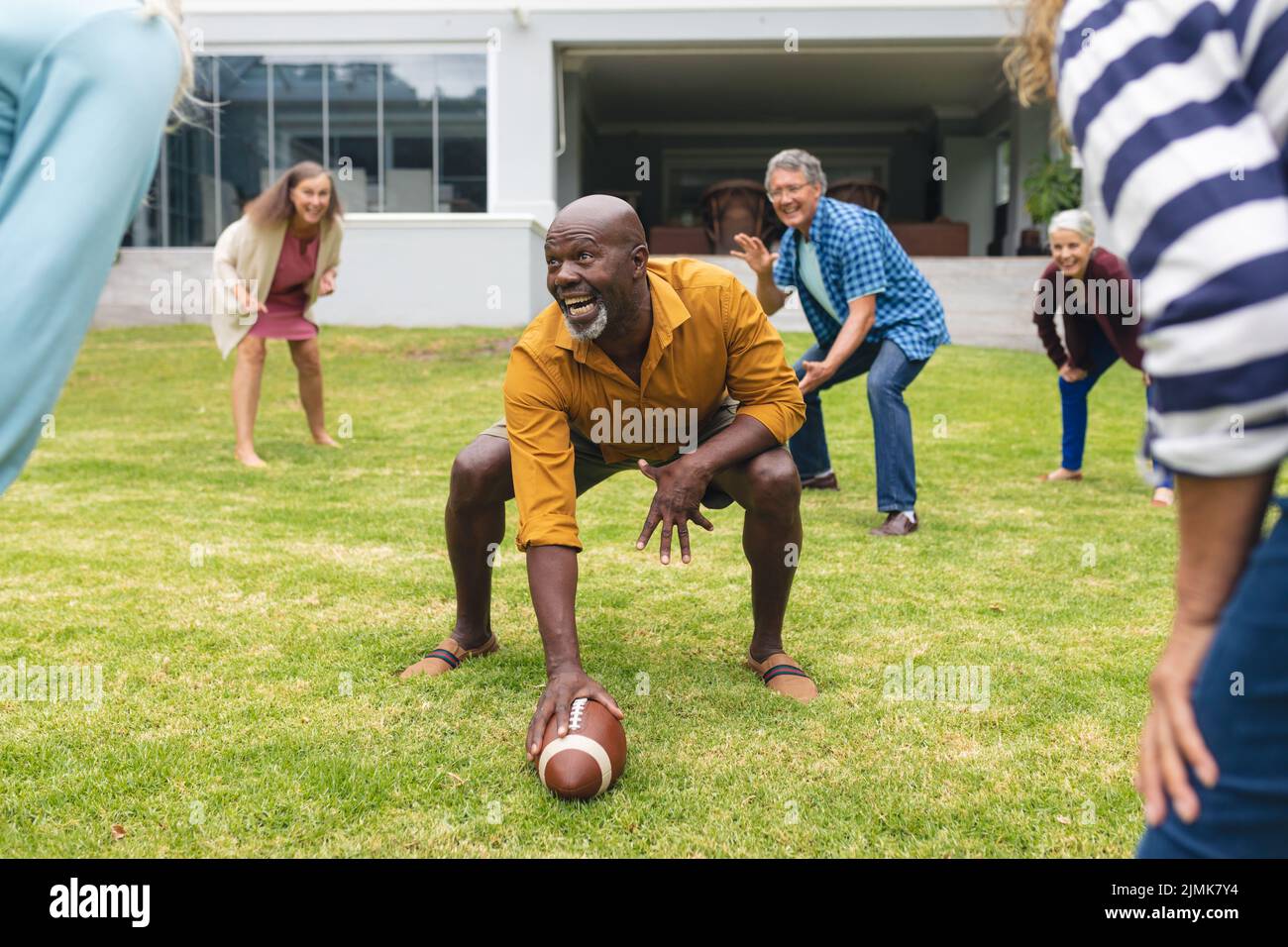 Happy african american senior man playing rugby with caucasian friends ...