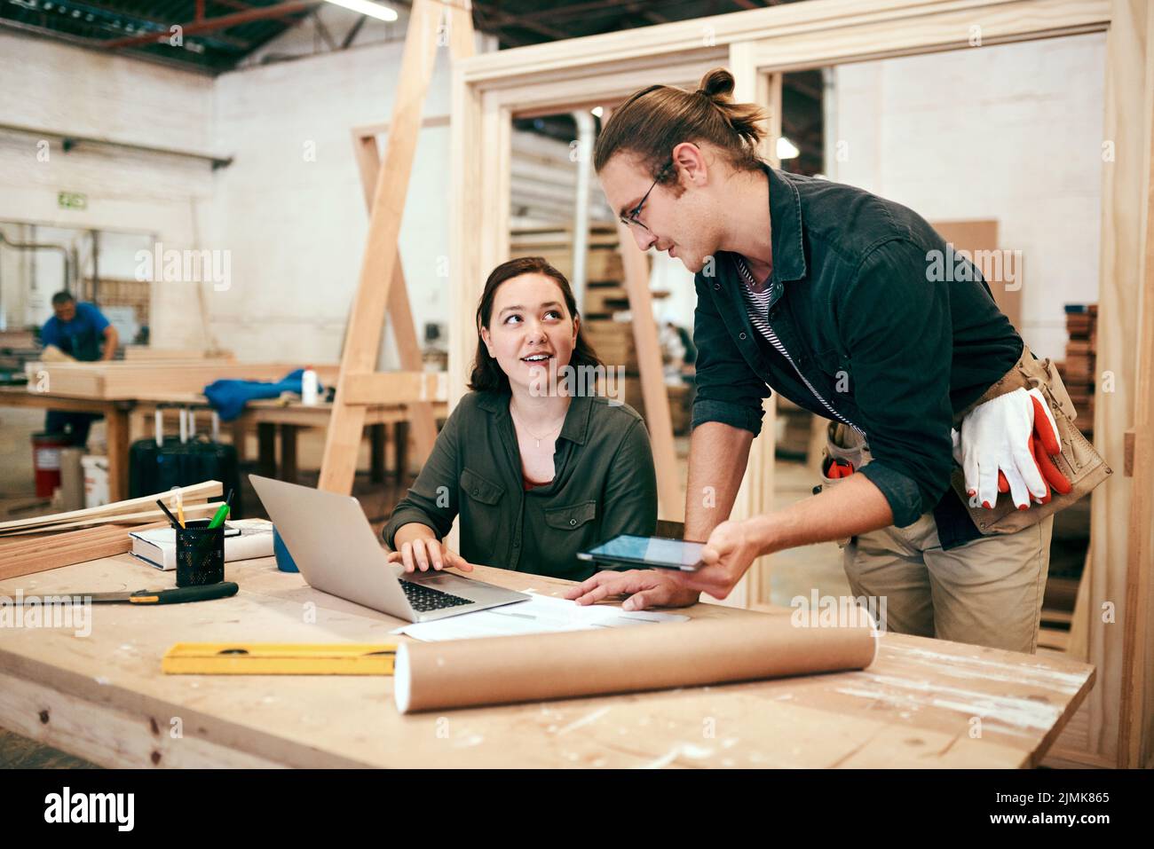 Technology is an asset to every business. two young carpenters using a ...