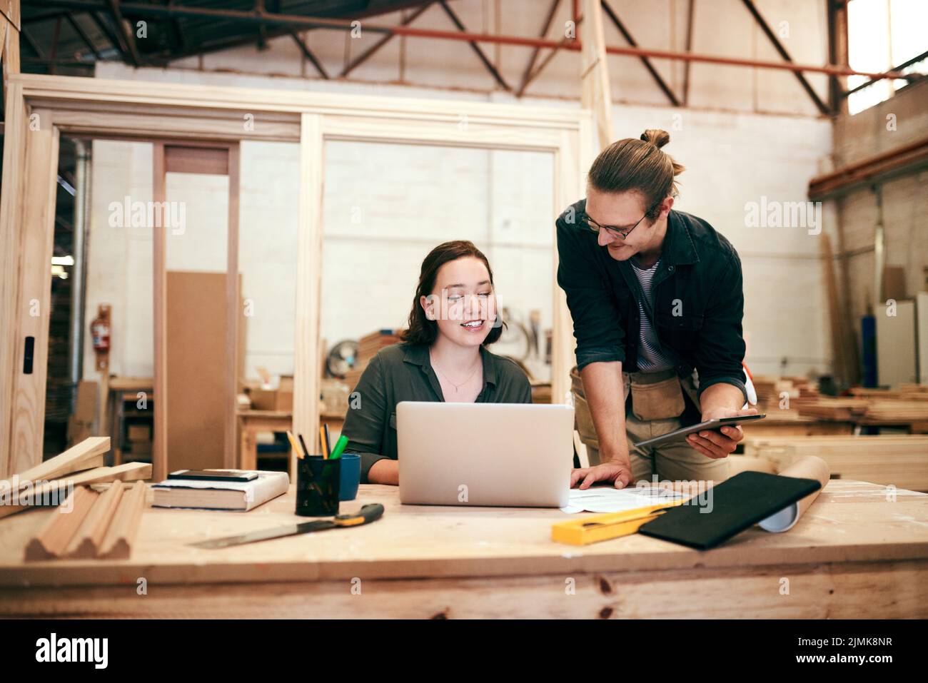 Were getting so much work done together. two young carpenters using a ...