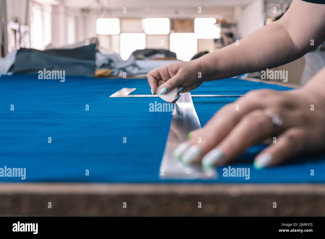 The cutter marks the fabric for cutting in the sewing workshop Stock ...