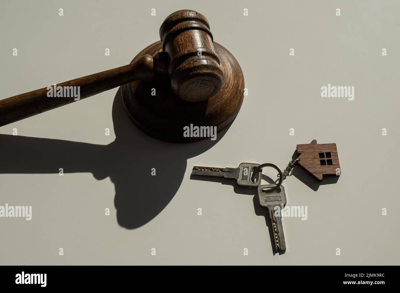 Keys with a keychain in the shape of a house and a judge's gavel on a ...