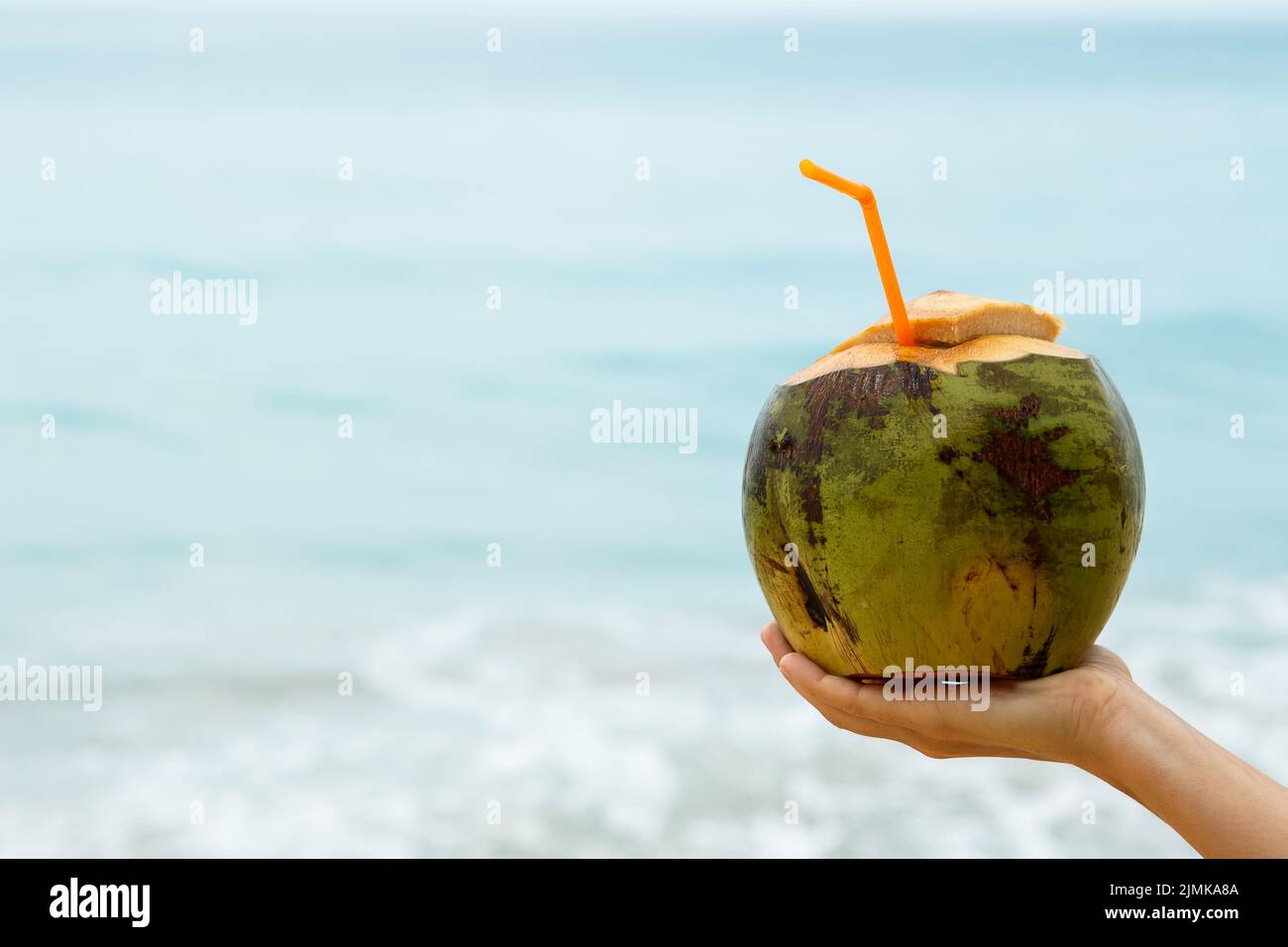 Female hand with a coconut drink on the beach Stock Photo - Alamy