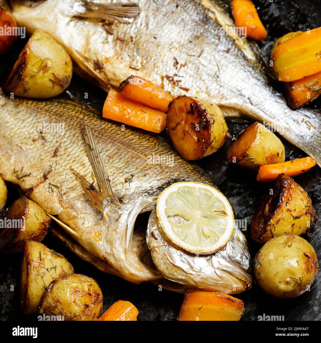 Baked Dorado fish baked with patatoes and carrot Stock Photo - Alamy