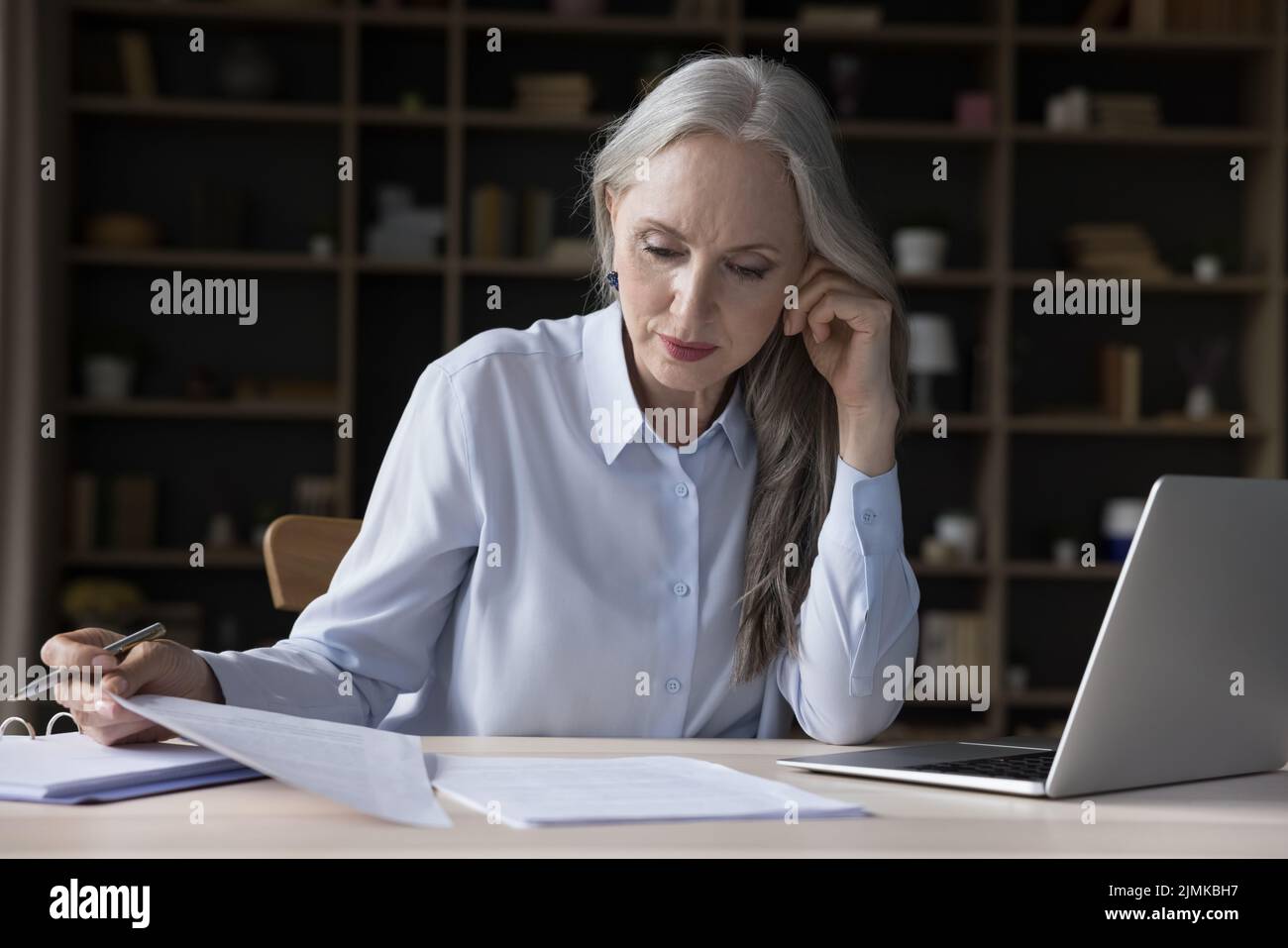 Focused busy elderly freelance business woman doing paperwork Stock ...