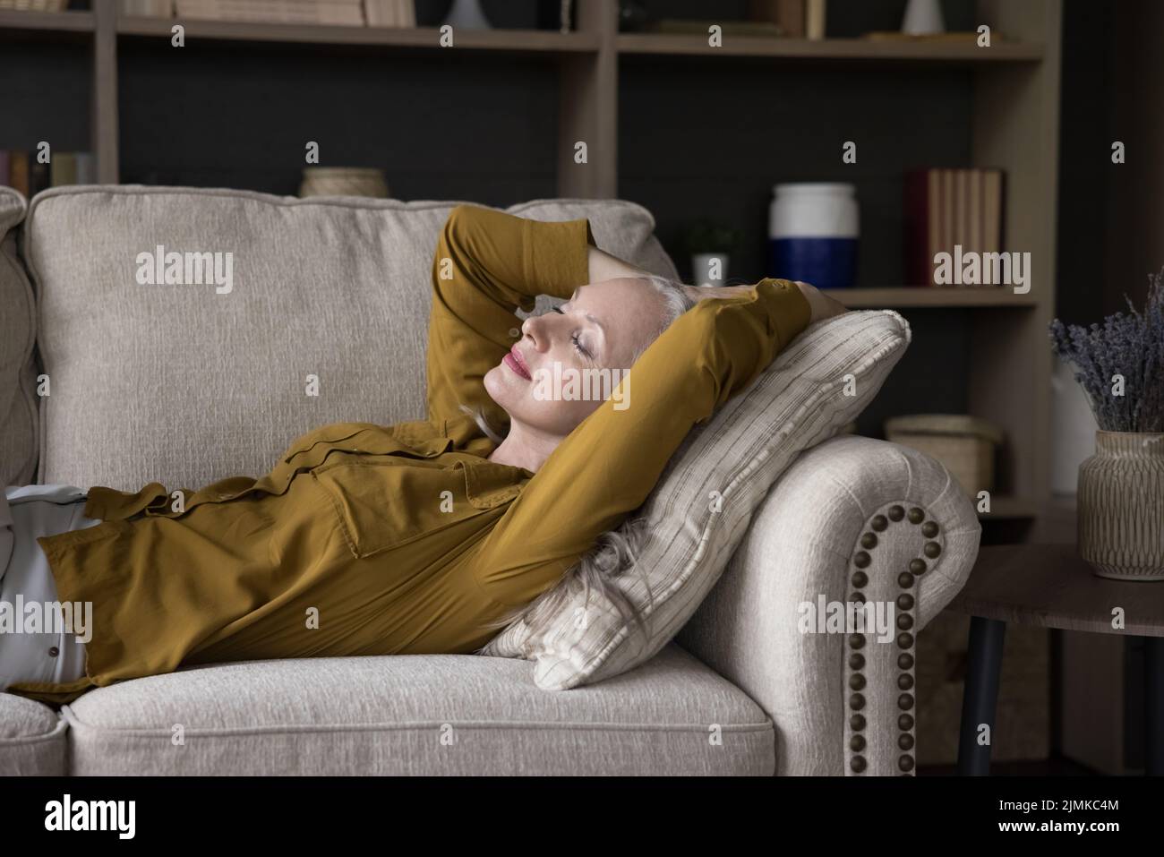Relaxed asleep elderly homeowner woman resting on couch Stock Photo - Alamy