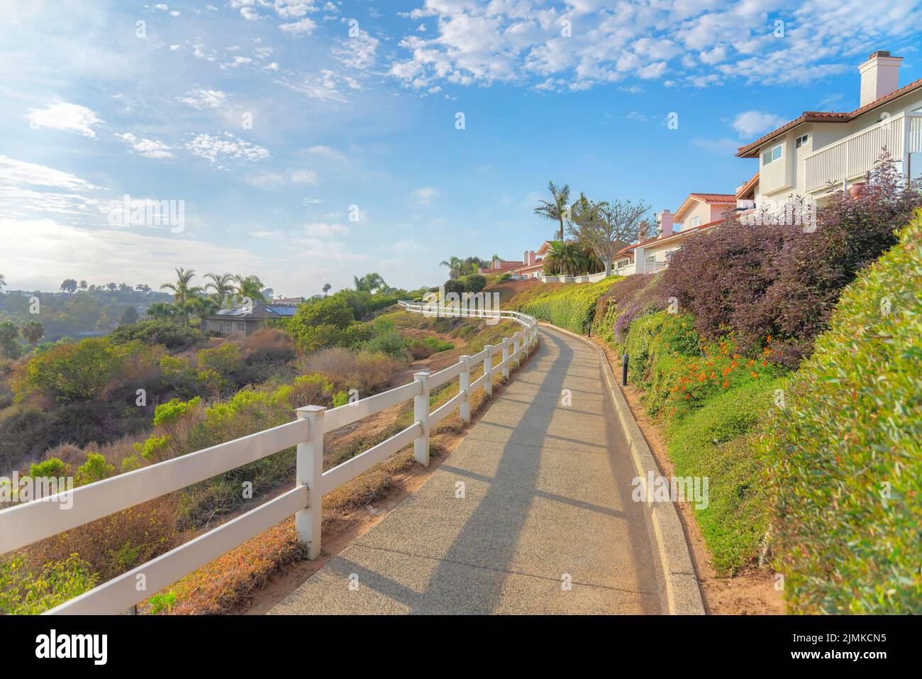 Concrete walkway and bike trail with railings in the residential area ...