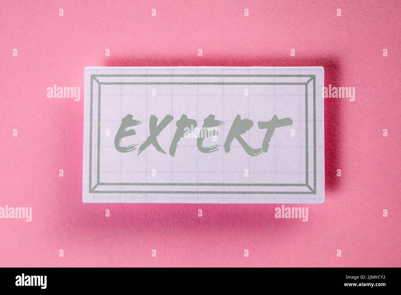 EXPERT. Text on a checkered piece of paper. Pink background Stock Photo ...